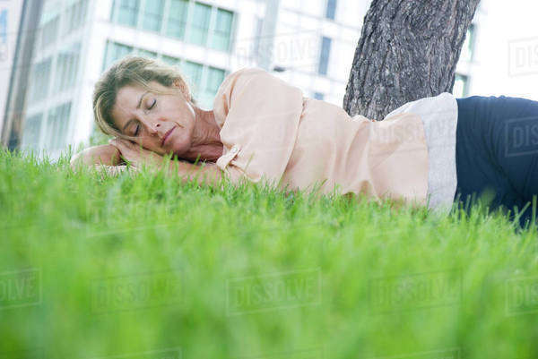 Woman napping in grass - Royalty-free Stock Photo | Dissolve