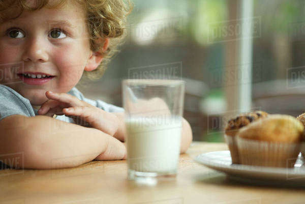 Little boy sitting at table with snack - Royalty-free Stock Photo ...