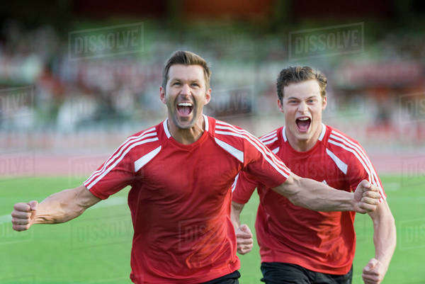 Soccer players shouting in victory - Stock Photo - Dissolve
