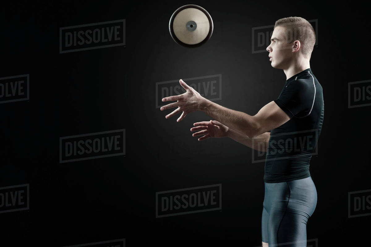 Male athlete throwing discus in air - Stock Photo - Dissolve