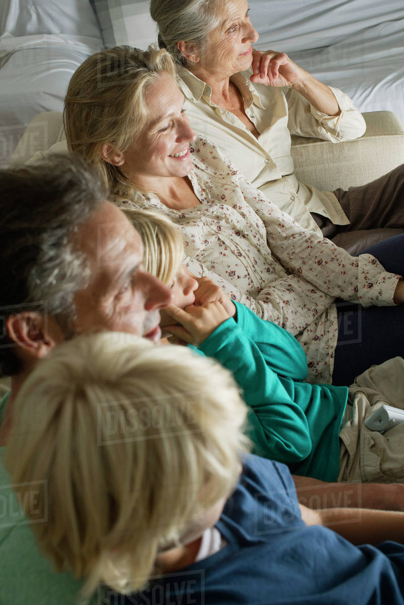 Multi-generation family sitting side by side on sofa, high angle view ...
