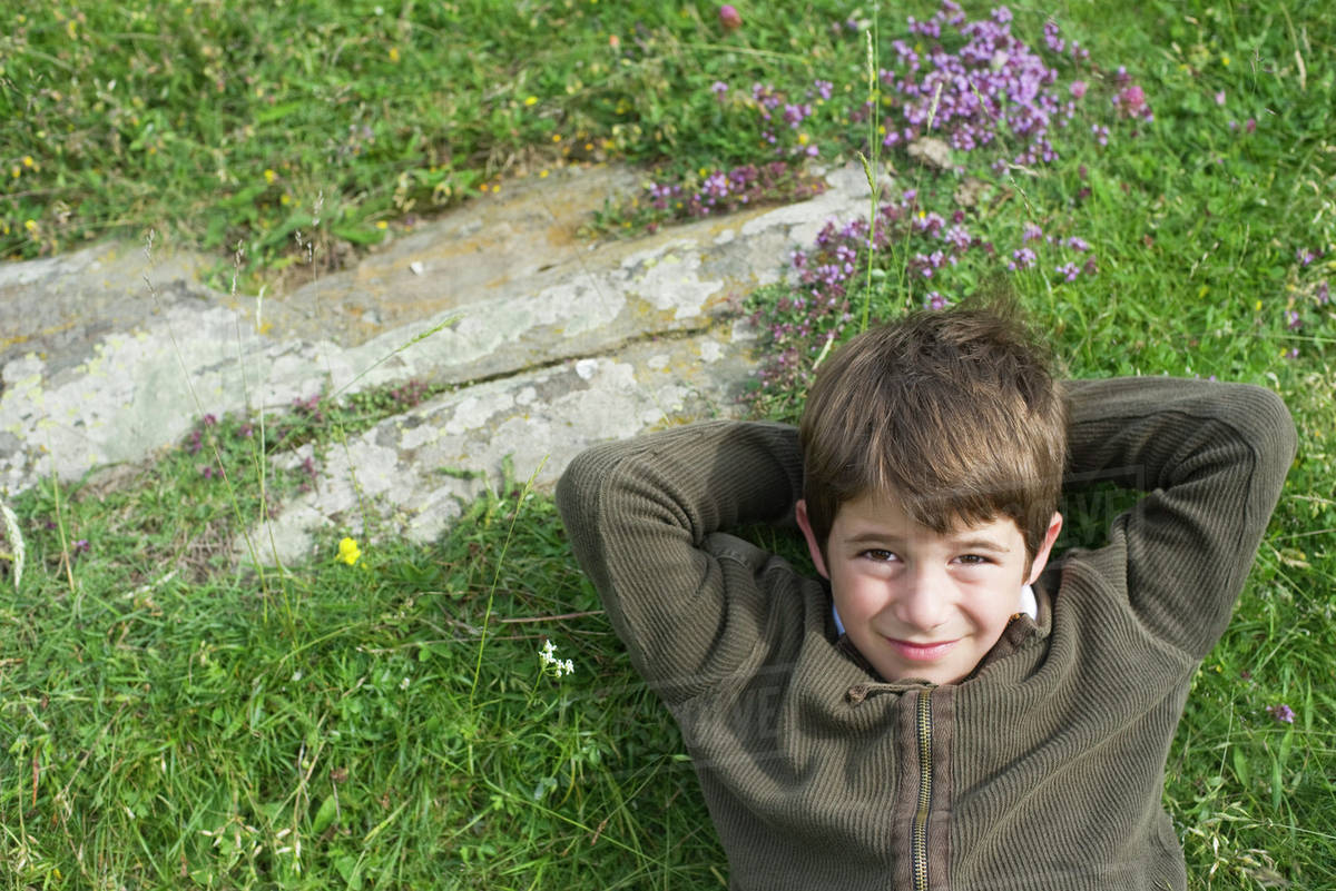 Boy relaxing on grass, portrait, directly above - Royalty-free Stock ...