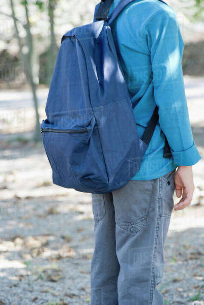 Boy carrying backpack, mid section - Royalty-free Stock Photo | Dissolve