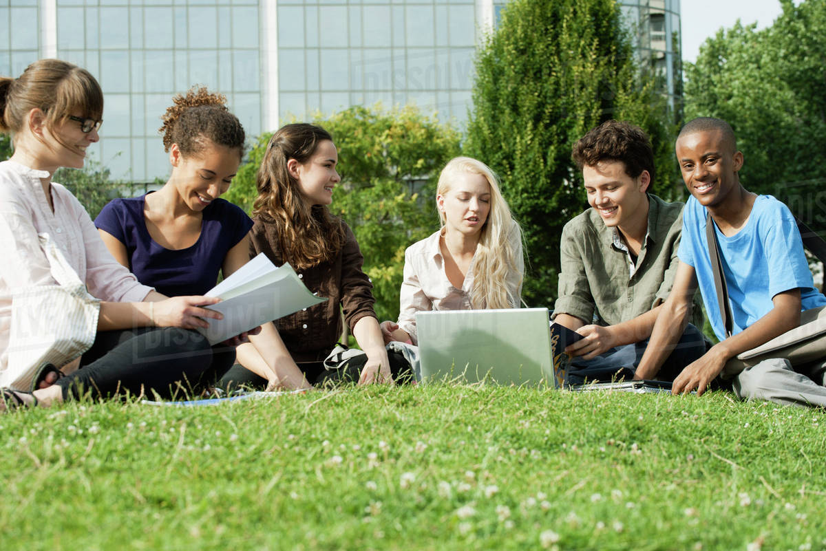University students studying on grass outdoors, low angle view ...