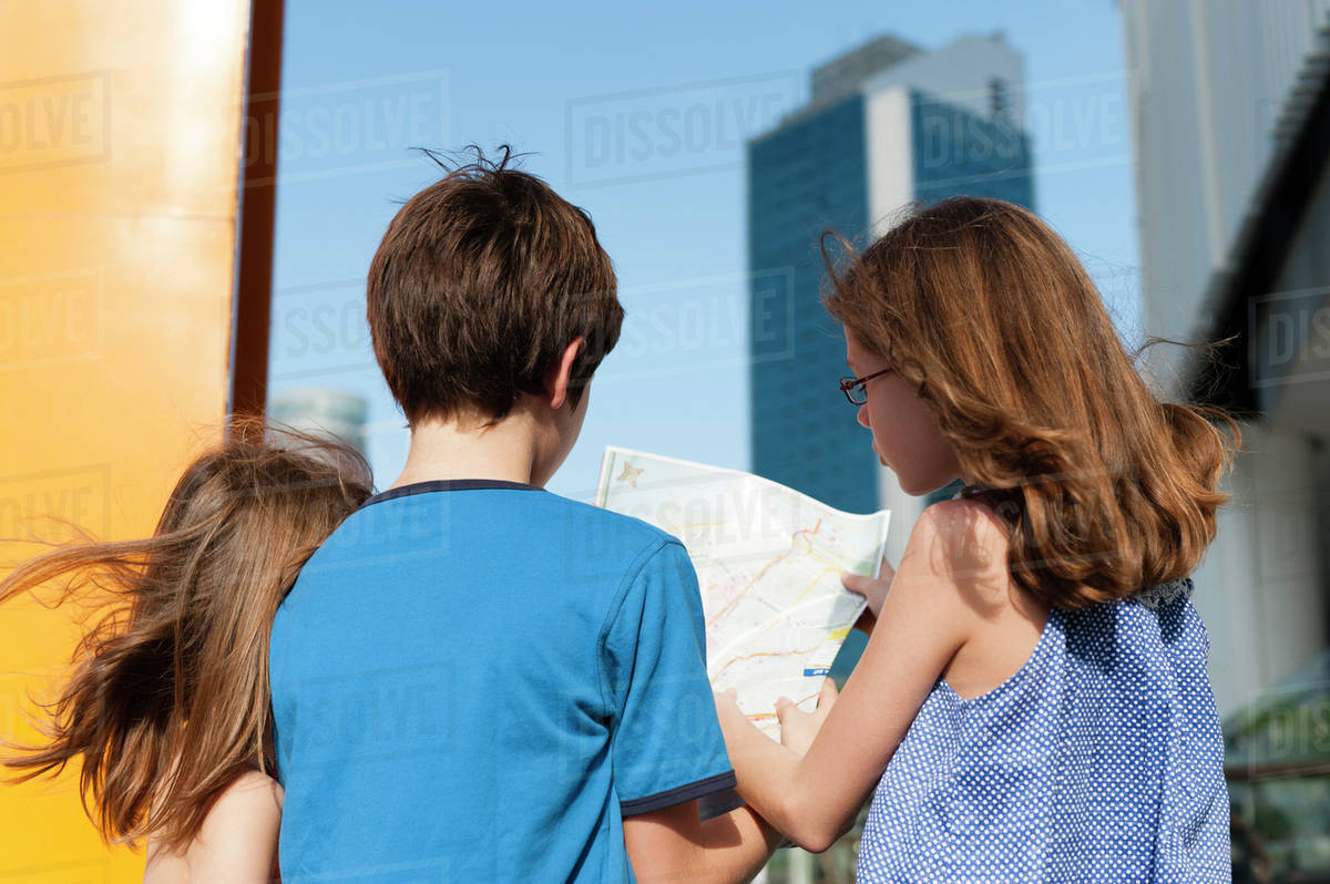 Children looking at map while sightseeing in city - Royalty-free Stock ...