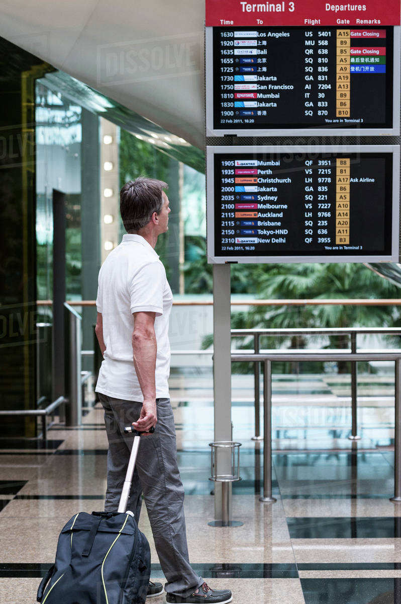 Man looking at arrival departure board in airport - Royalty-free Stock ...
