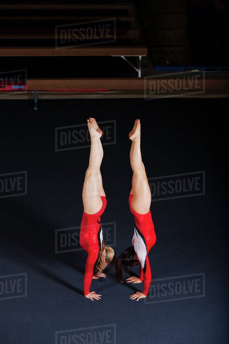 Female gymnasts performing handstands back to back - Royalty-free Stock ...