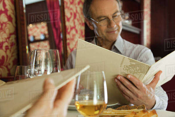 Mature man looking at menu in restaurant - Royalty-free Stock Photo ...