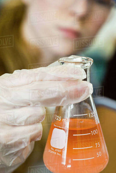 Researcher holding beaker filled with chemicals - Royalty-free Stock ...
