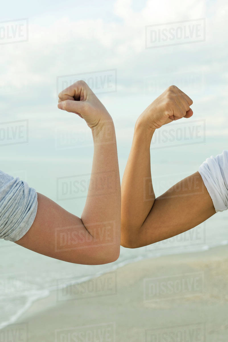 Women flexing arms, cropped - Royalty-free Stock Photo | Dissolve