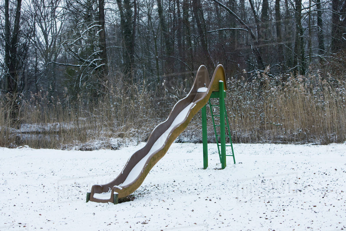 Playground slide covered in snow - Stock Photo - Dissolve
