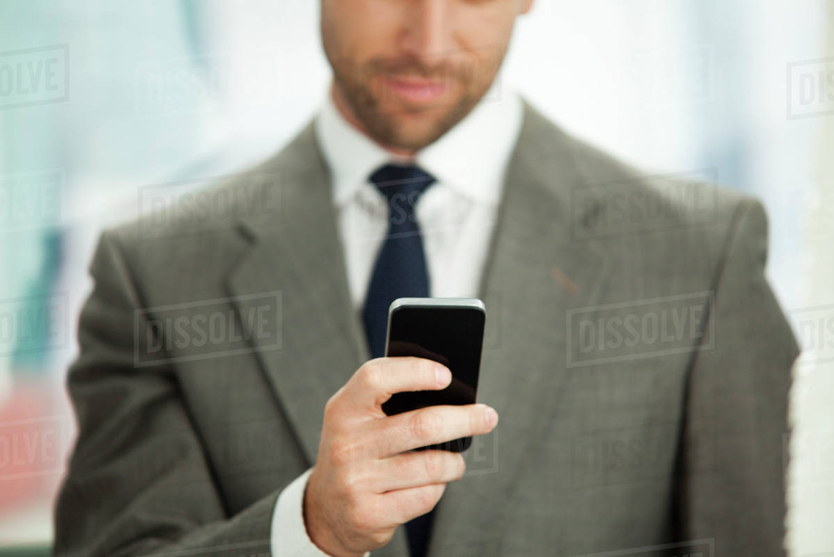 Businessman sending text message on cell phone, cropped - Stock Photo ...