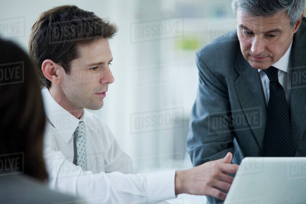 Business associates collaborating with laptop computer - Stock Photo ...