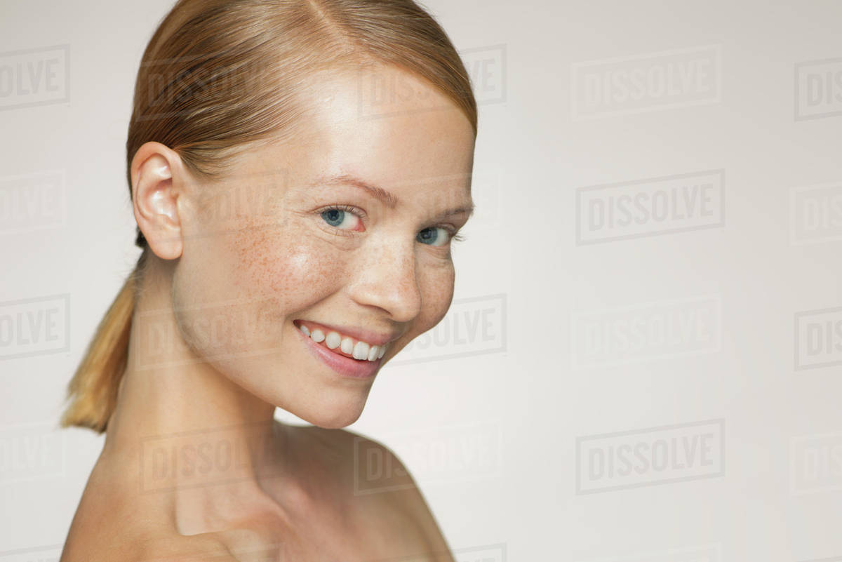 Young woman smiling coyly - Stock Photo - Dissolve