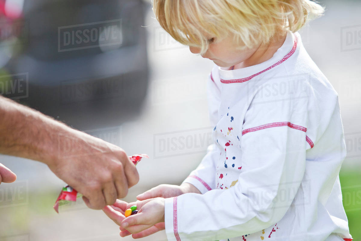 Man giving child candies - Stock Photo - Dissolve