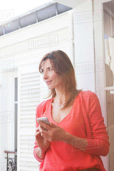 Woman by open window looking at view - Stock Photo - Dissolve