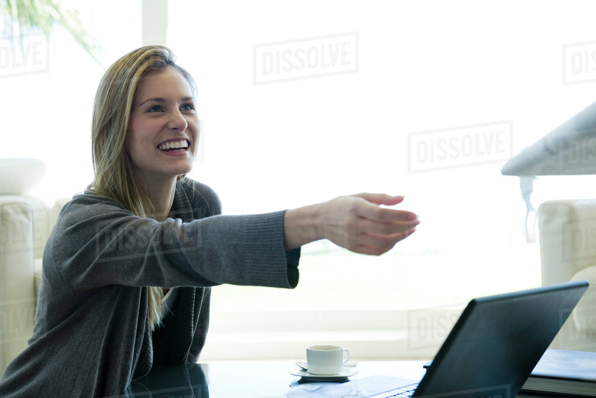 Woman reaching for paper being handed to her by person out-of-frame ...