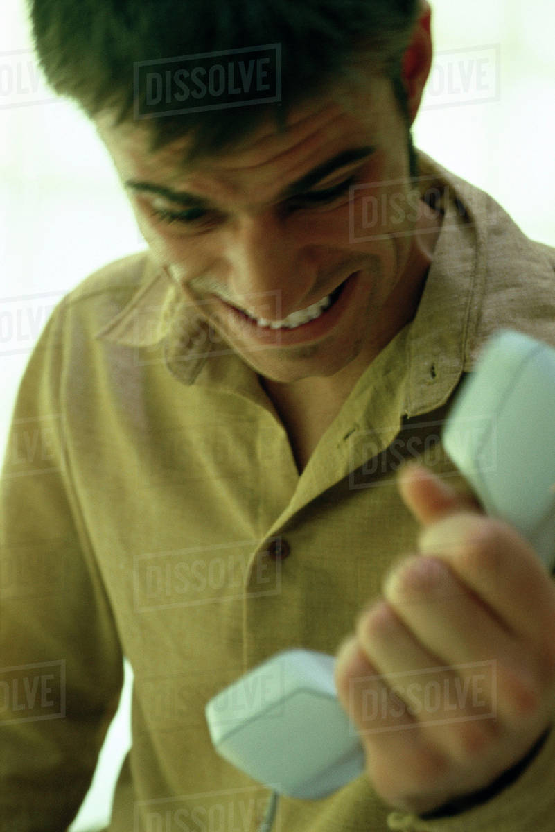 Man gripping phone receiver, grimacing - Royalty-free Stock Photo ...