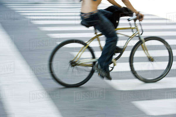 Person riding bicycle over crosswalk - Royalty-free Stock Photo | Dissolve