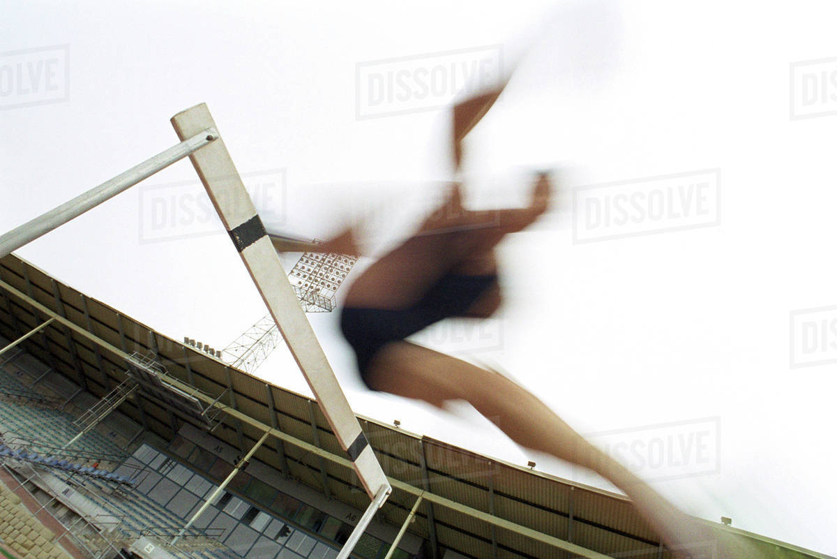 Runner jumping over hurdle, blurred - Royalty-free Stock Photo | Dissolve