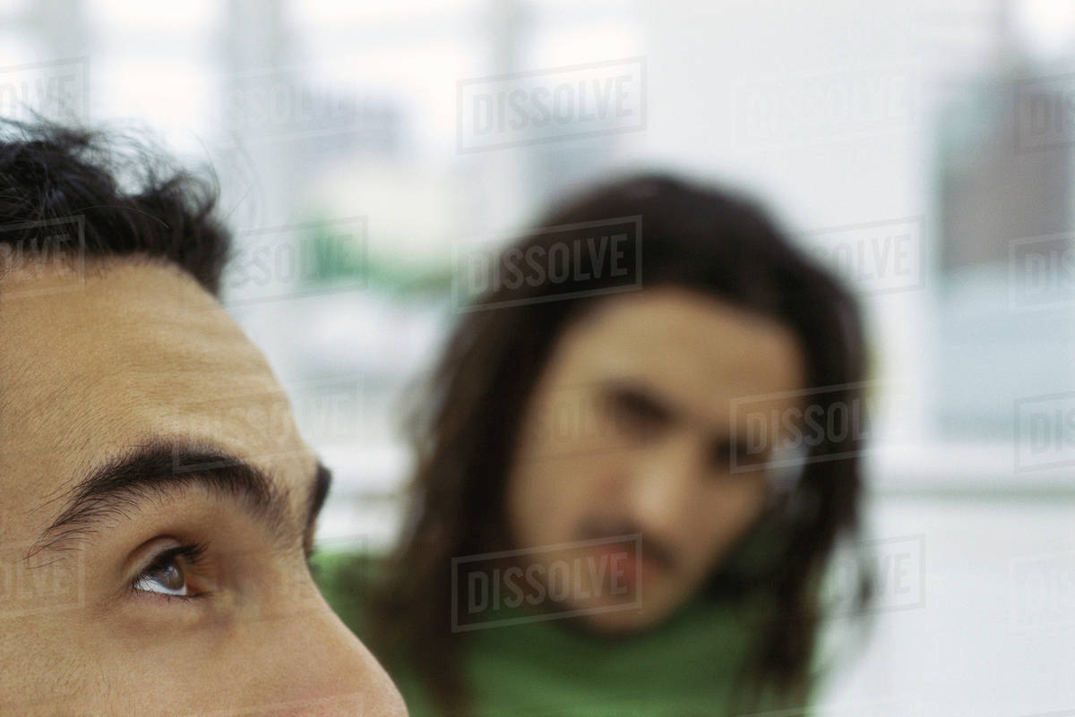 Man looking up, friend watching in background, cropped - Stock Photo ...