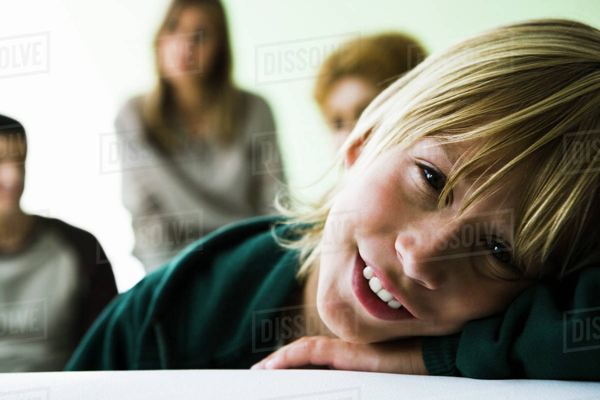 Boy resting head on arms, smiling at camera - Royalty-free Stock Photo ...