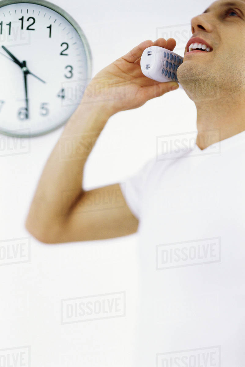Man on phone call, clock in background - Stock Photo - Dissolve