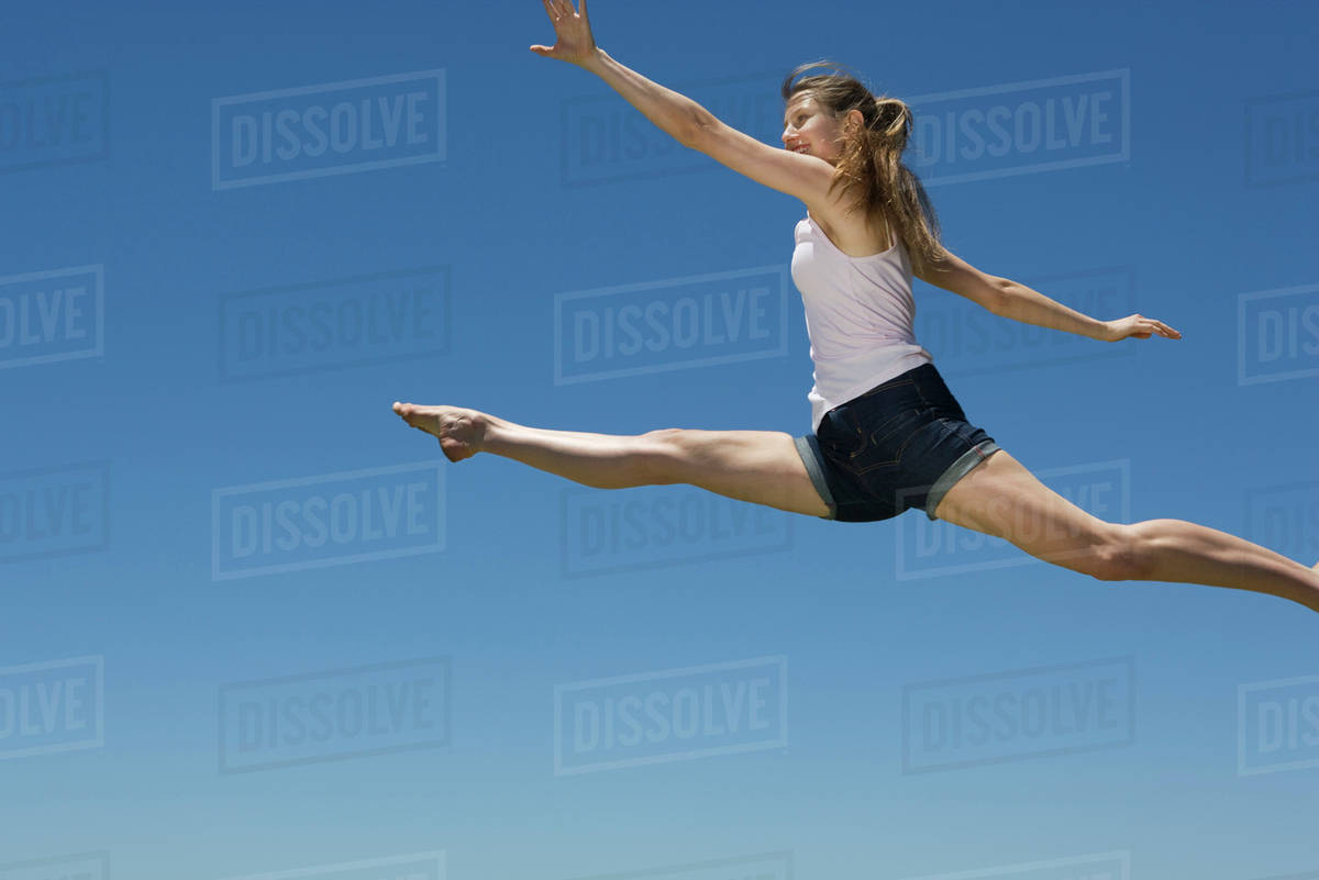 Young woman leaping, midair - Royalty-free Stock Photo | Dissolve