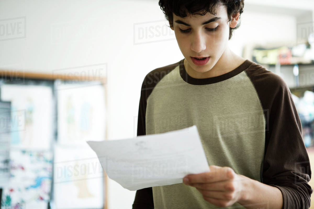 High school student reading report aloud in class - Stock Photo - Dissolve