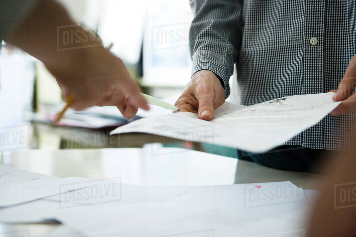 Colleagues reviewing document together - Royalty-free Stock Photo ...