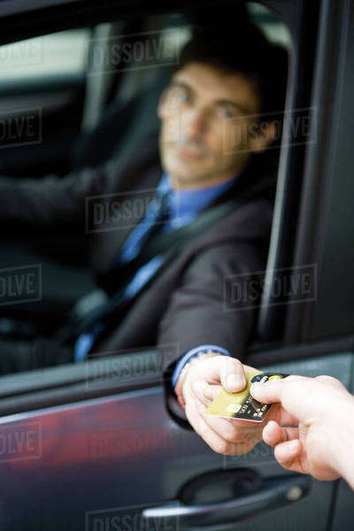 Customer in drive-thru handing credit card to check-out window clerk ...