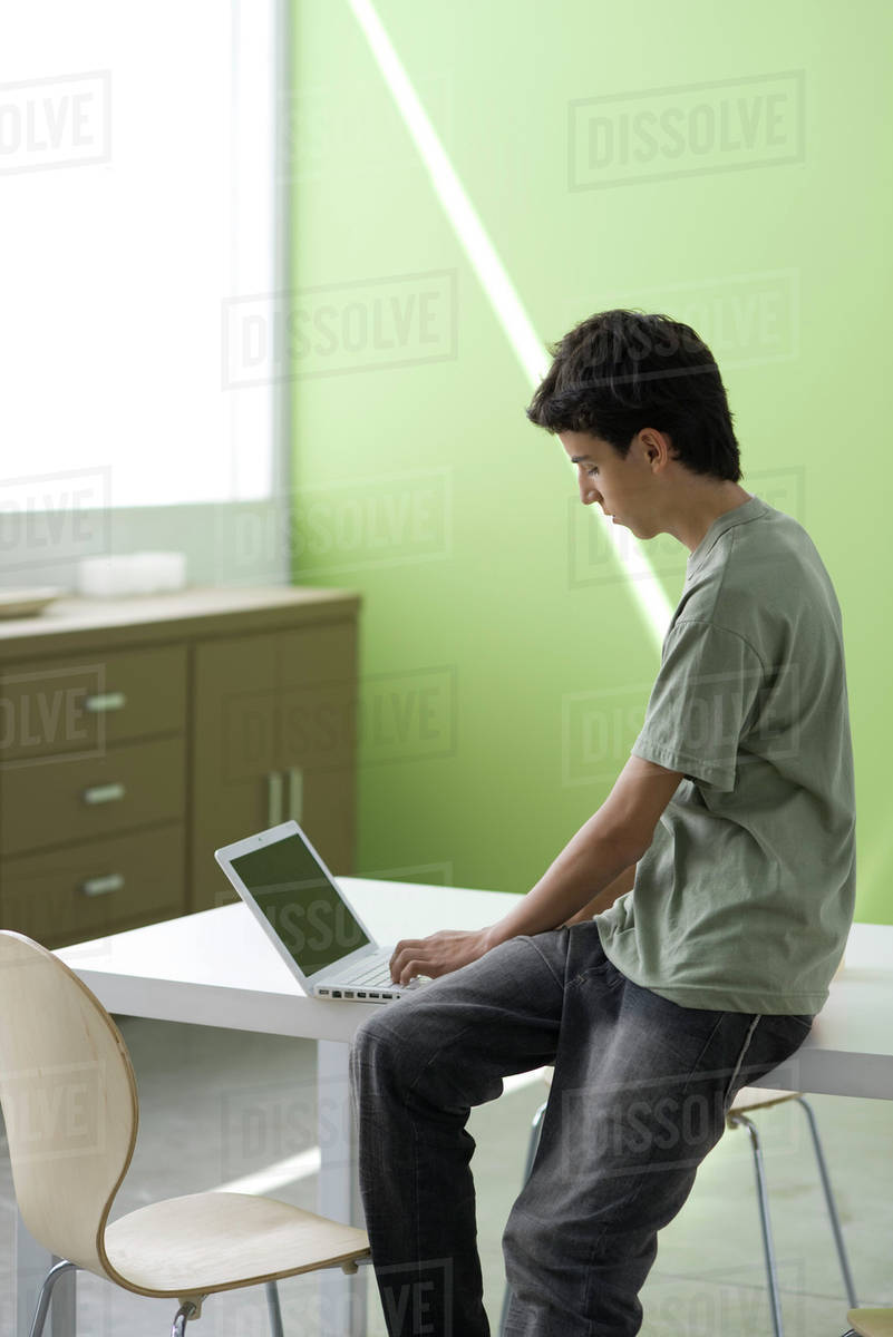 Teenage boy using laptop computer - Royalty-free Stock Photo | Dissolve