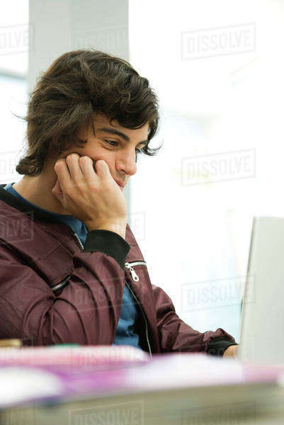 Young man using laptop - Royalty-free Stock Photo | Dissolve