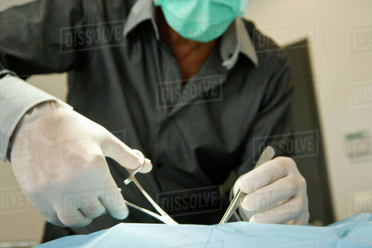Doctor performing surgery - Stock Photo - Dissolve