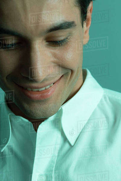 Man smiling, looking down, close-up - Royalty-free Stock Photo | Dissolve