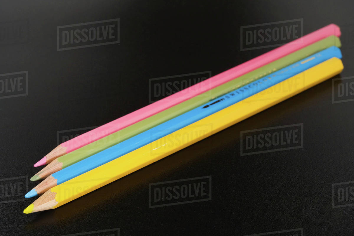 Four colored pencils side by side, close-up - Stock Photo - Dissolve