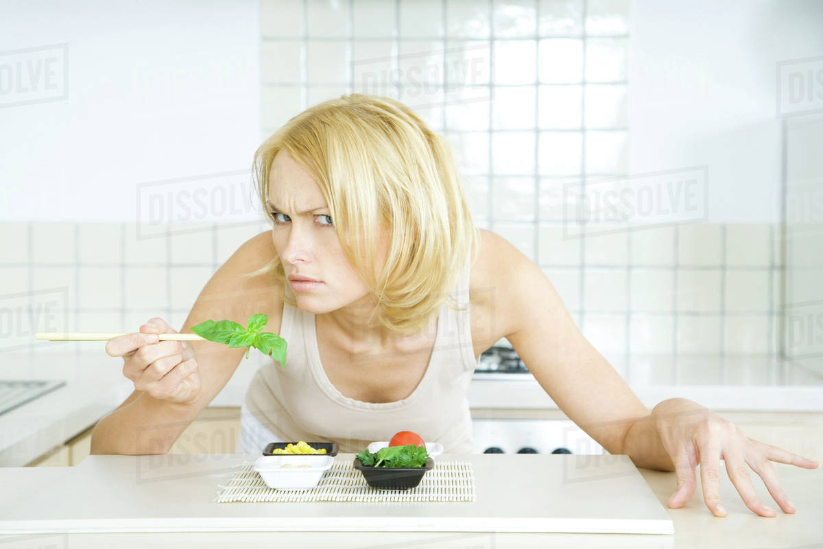 Woman leaning over food, looking at camera threateningly - Royalty-free ...