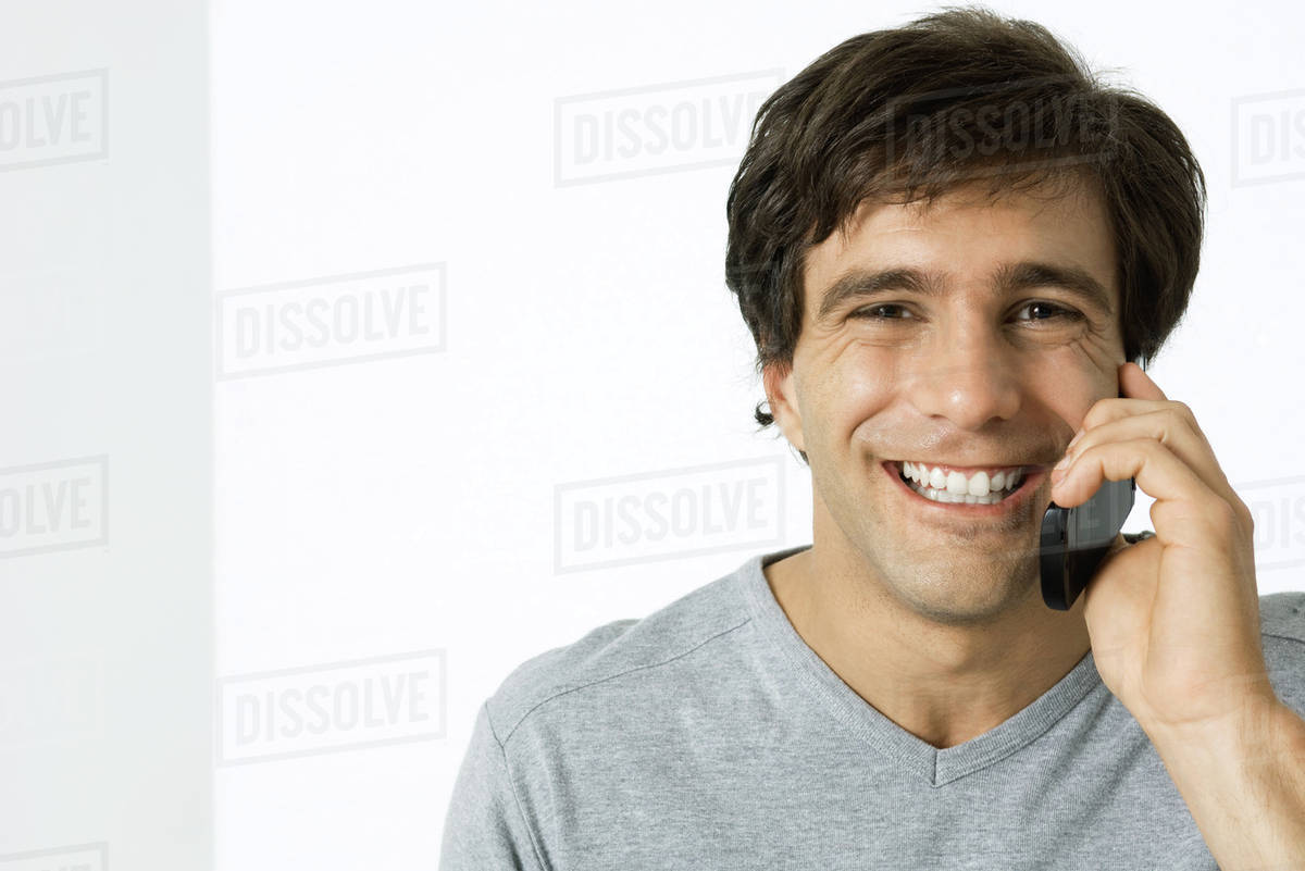 Man using cell phone, smiling at camera - Royalty-free Stock Photo ...
