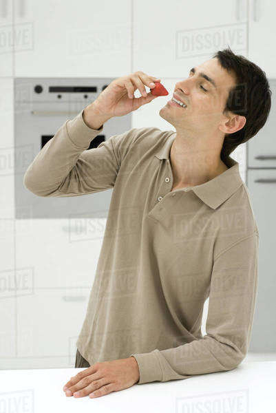 Man eating fresh strawberry, head back, eyes closed - Royalty-free ...