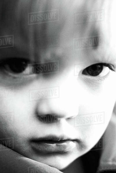 Little boy frowning at camera, portrait, close-up - Stock Photo - Dissolve