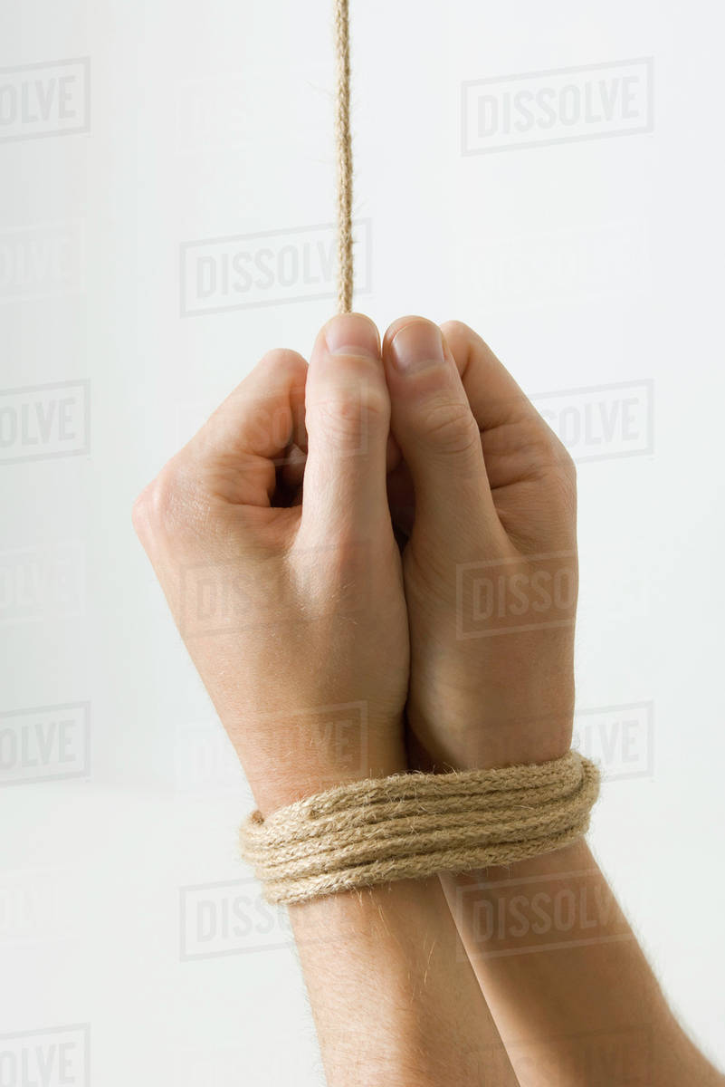 Hands bound with rope, close-up - Stock Photo - Dissolve