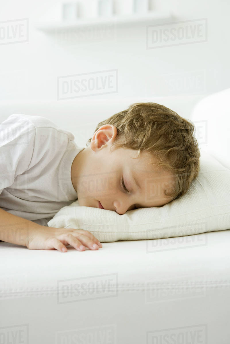 Little boy napping on bed, eyes closed - Stock Photo - Dissolve