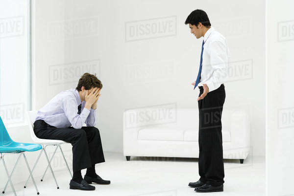 Professional man reprimanding employee, employee covering face with ...