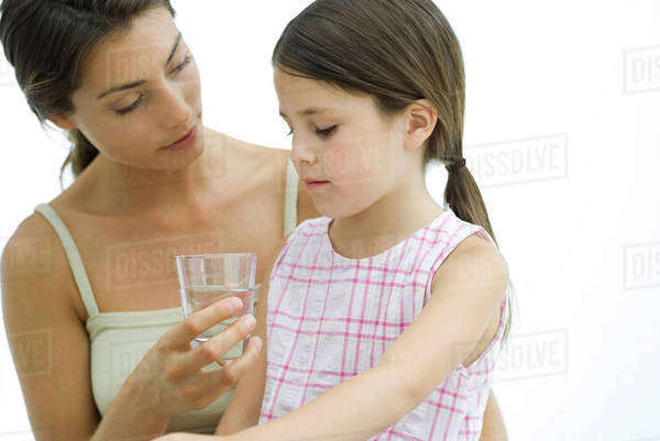 Mother offering glass of water to daughter - Royalty-free Stock Photo ...
