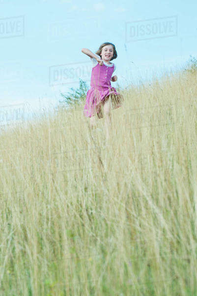 Girl running through tall grass - Stock Photo - Dissolve