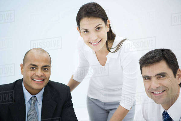 Business associates smiling at camera, portrait - Stock Photo - Dissolve