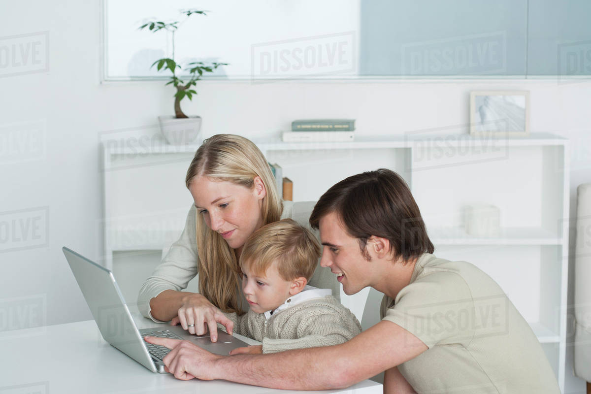 Parents and little boy using laptop computer together - Royalty-free ...