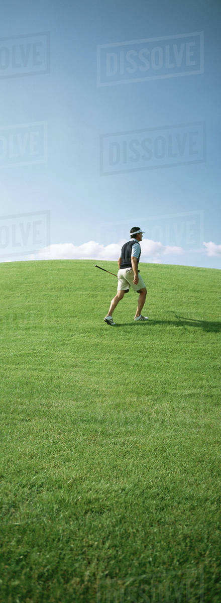 Golfer walking - Stock Photo - Dissolve