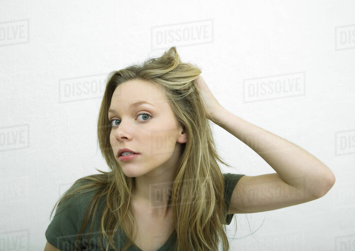 Teenage girl pushing hair back and looking at camera, portrait - Stock ...
