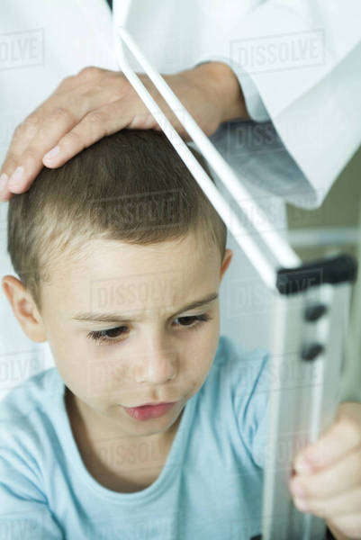 Doctor measuring boy during check-up - Royalty-free Stock Photo | Dissolve